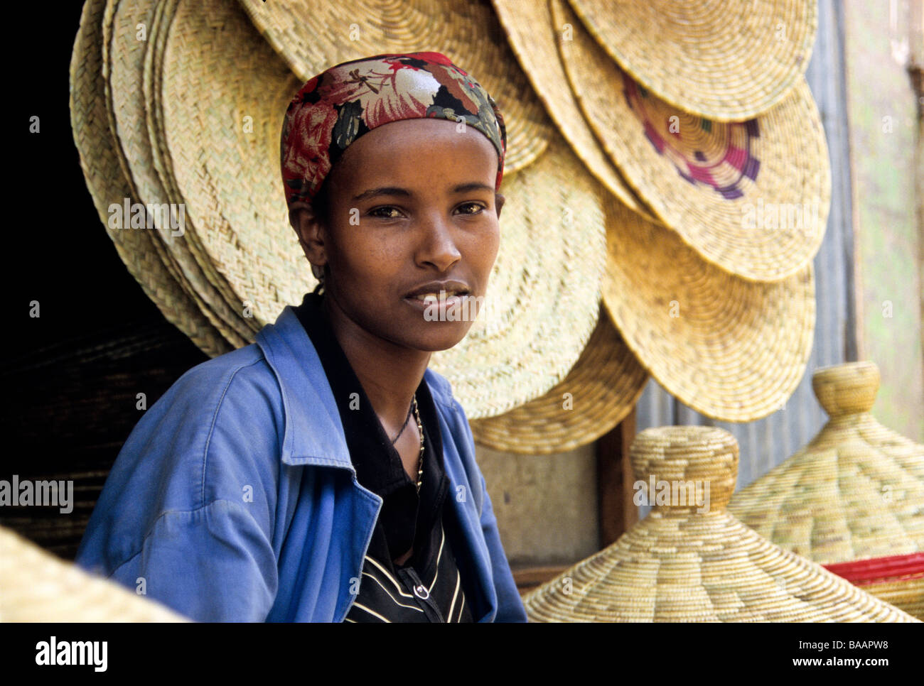 Portrait of a young girl selling straw hats and baskets at Addis Kelema ...