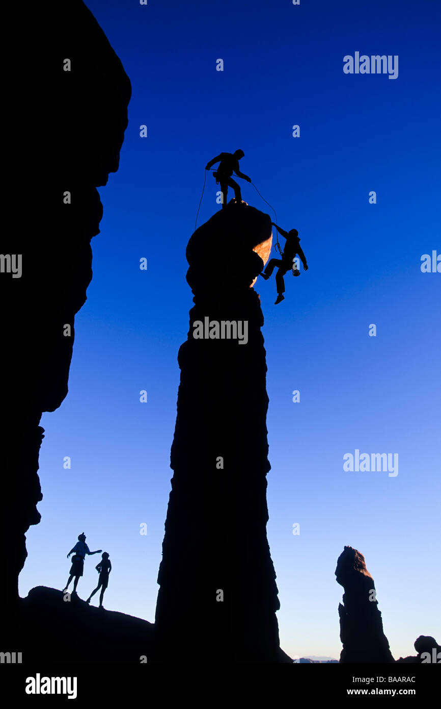 Team of rock climbers reaching the summit Stock Photo - Alamy