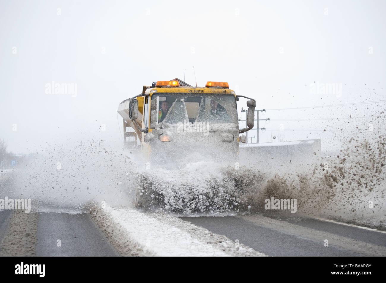 Gritter lorry with snow plough fitted to the front clearing the roads ...