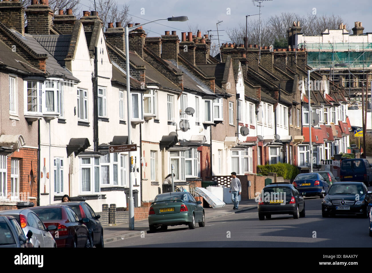 Traffic and parked cars on a suburban street in Lewisham London England ...