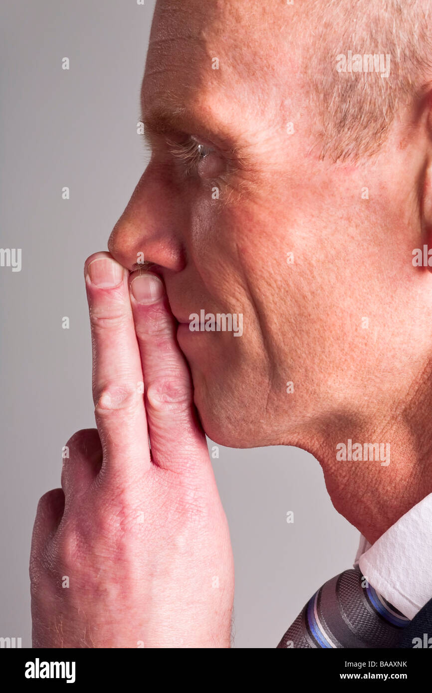 Profile of businessman with hand on chin Stock Photo - Alamy