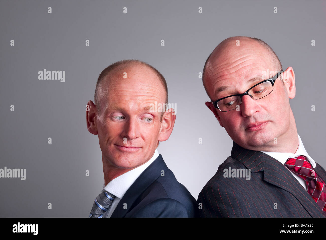 Two businessmen looking over their shoulders Stock Photo - Alamy