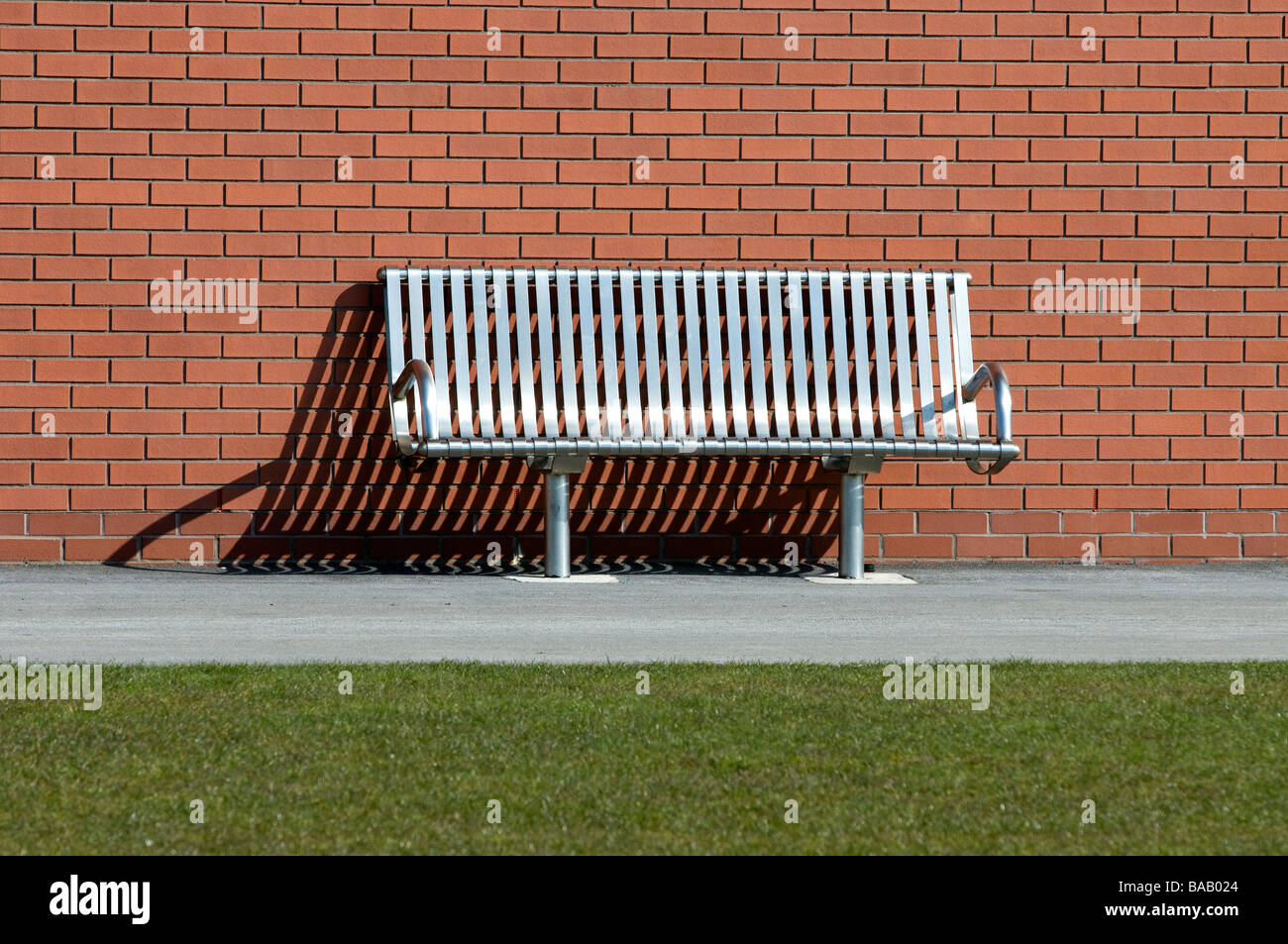 Stainless steel bench against red brick wall with harsh shadows Stock ...