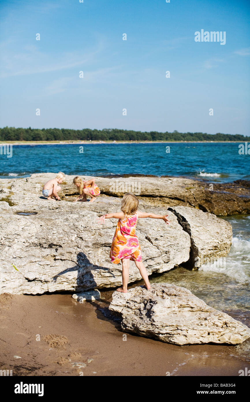 Children playing on cliffs by the ocean, Gotland, Sweden Stock Photo ...