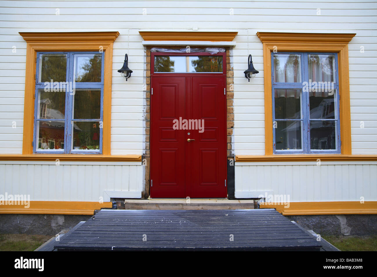 A red door on a white house Stock Photo - Alamy