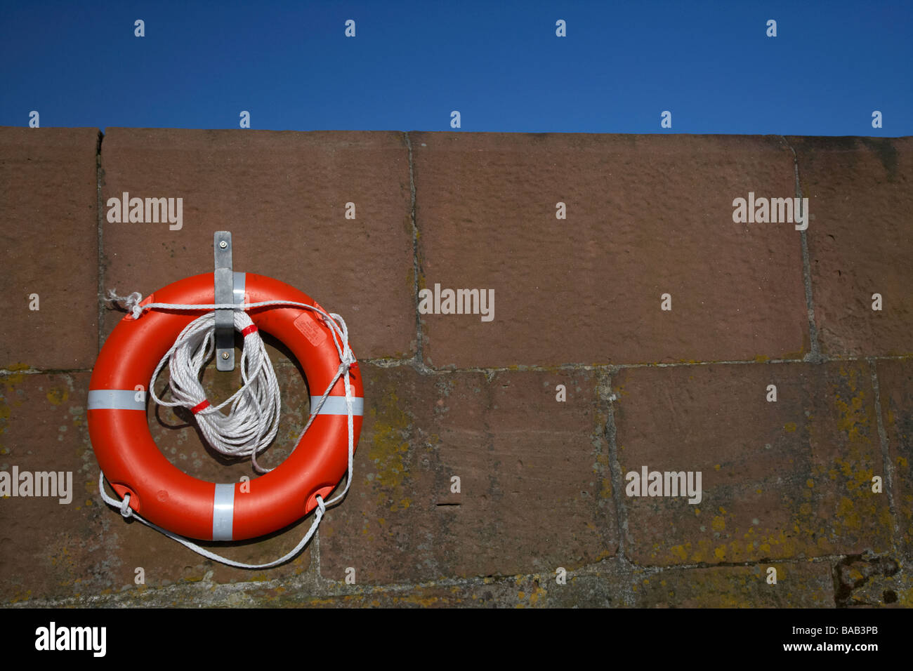 brand new bright red lifebelt with white rope hanging on a hanger on ...