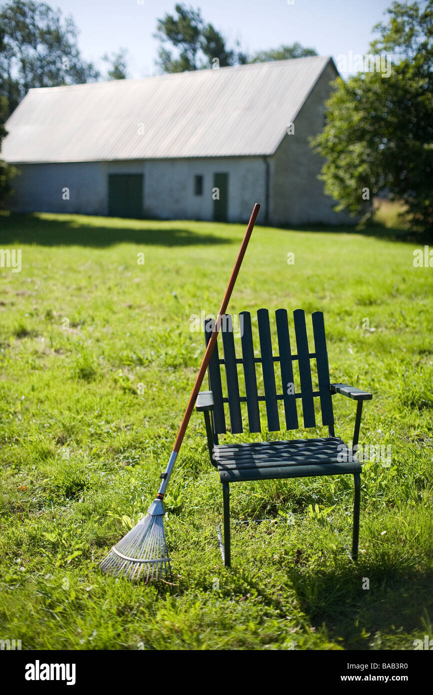 A rake against a chair in a garden, sweden Stock Photo - Alamy