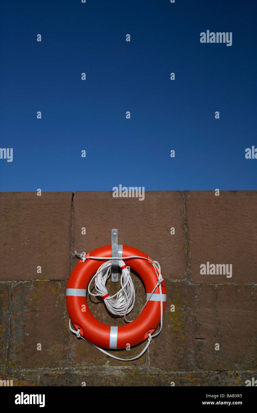 brand new bright red lifebelt with white rope hanging on a hanger on ...