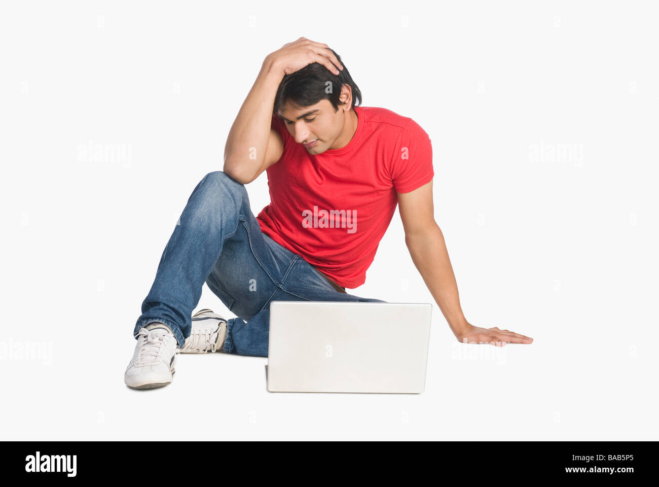 Man sitting in front of a laptop Stock Photo - Alamy