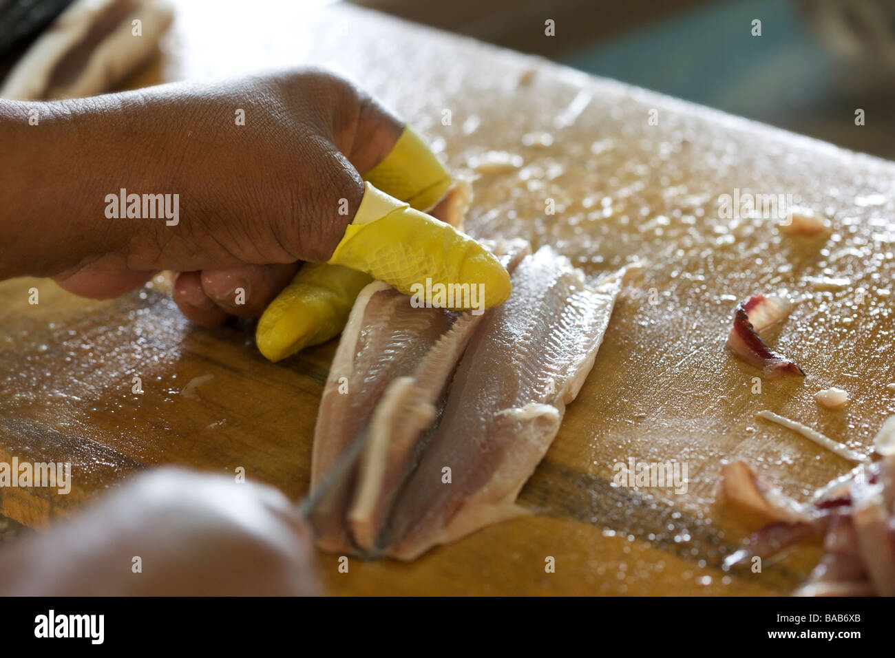 Butcher filleting flying fish (The Exocoetidae) at Oistins Fish Market ...