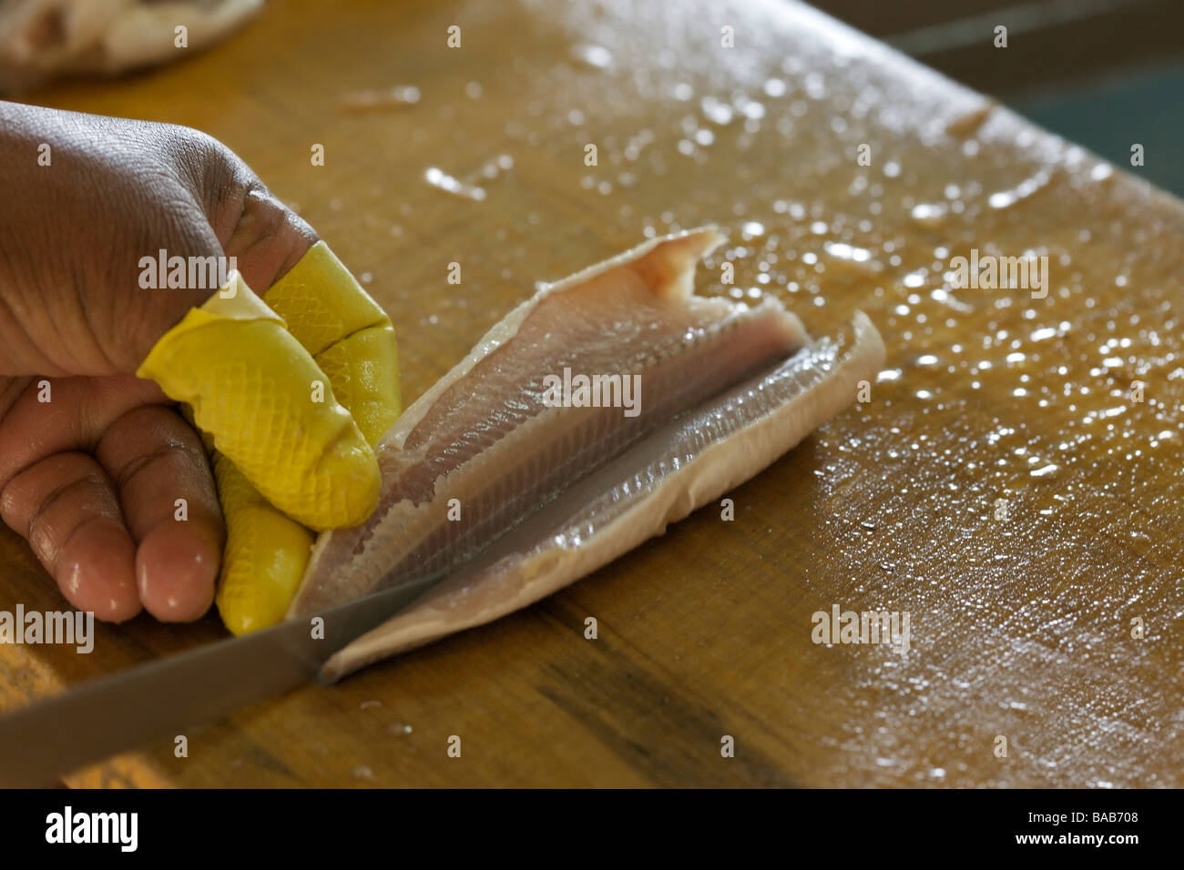 Butcher filleting flying fish (The Exocoetidae) at Oistins Fish Market ...