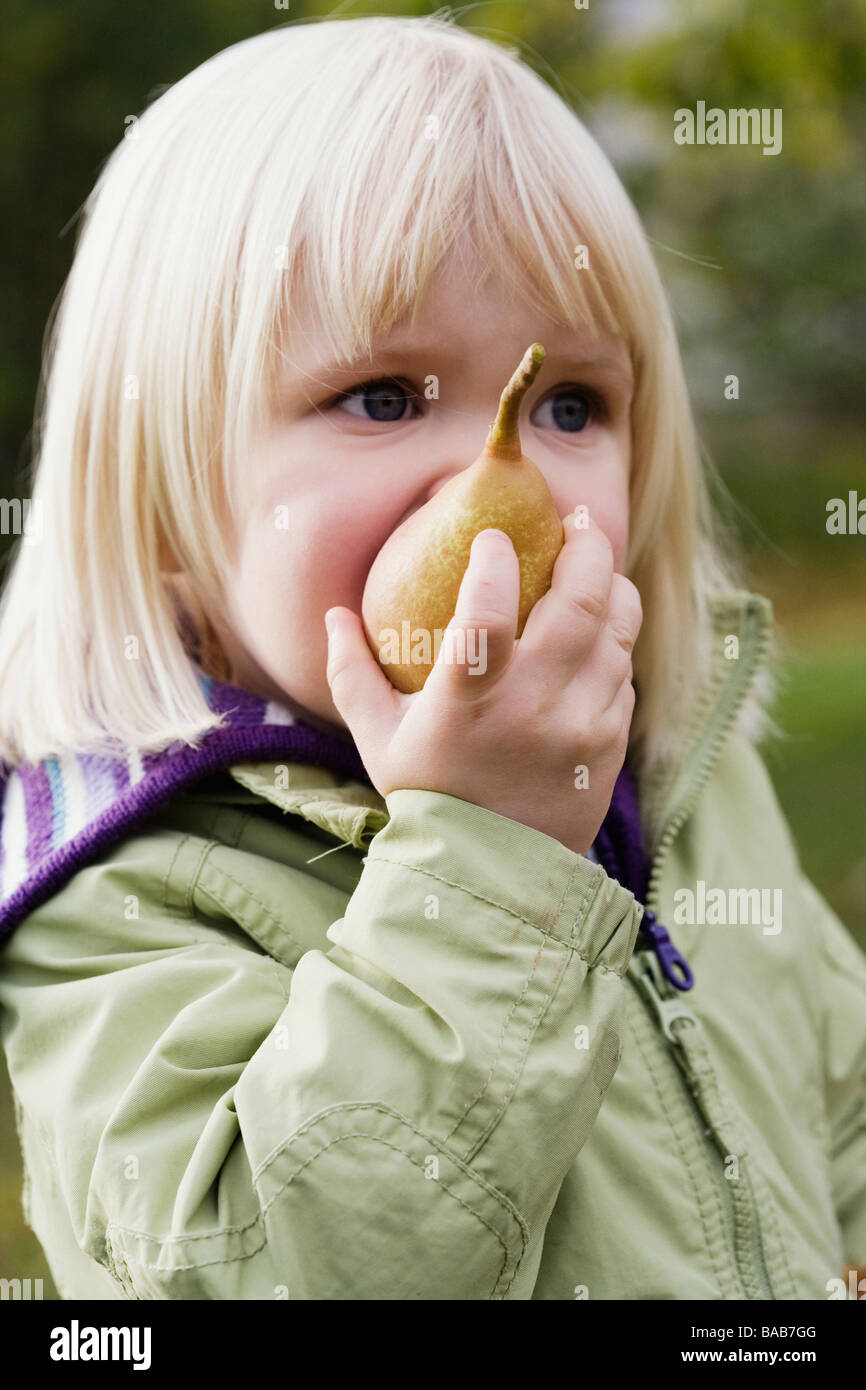 A girl eating a pear, Nacka, Sweden Stock Photo - Alamy