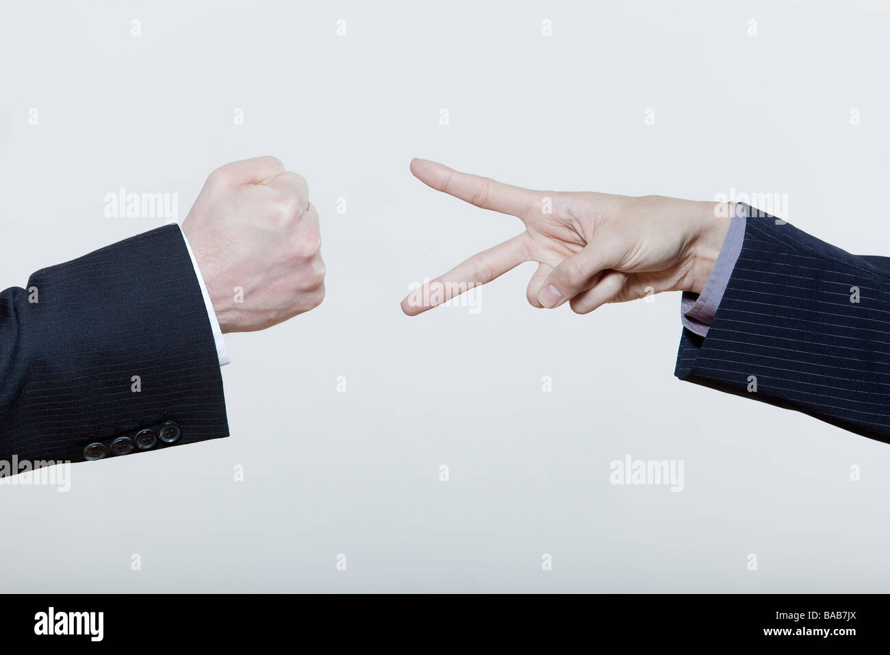 two men playing rock paper scissors on studio isolated white background ...