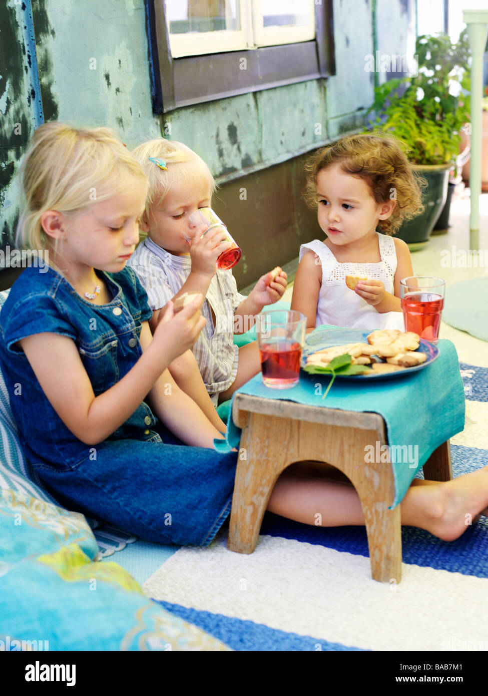 Three children eating cookies on a balcony Sweden Stock Photo - Alamy