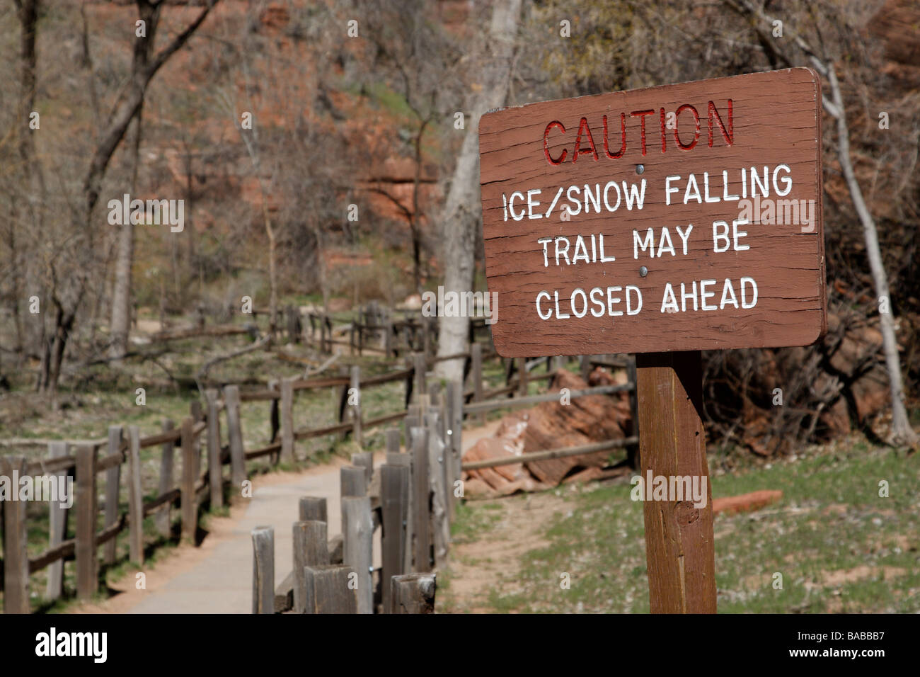 caution sign warning hikers of falling ice or snow at the riverside ...
