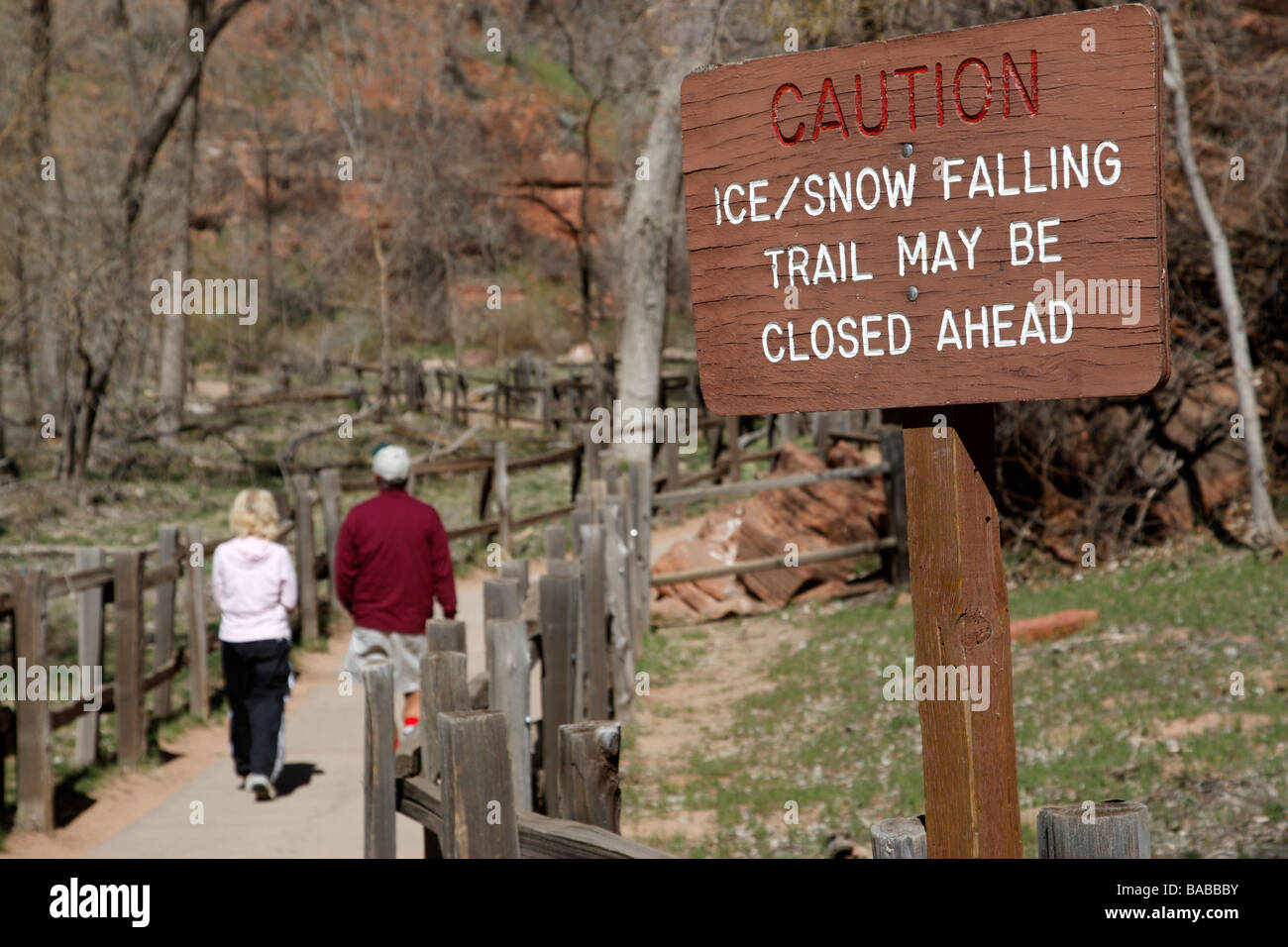 caution sign warning hikers of falling ice or snow at the riverside ...