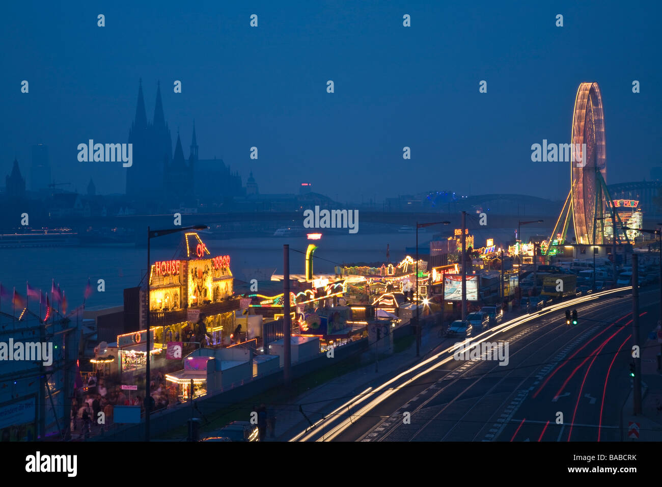 Fair at night beside the Rhine in Cologne with silhouette of Cologne ...