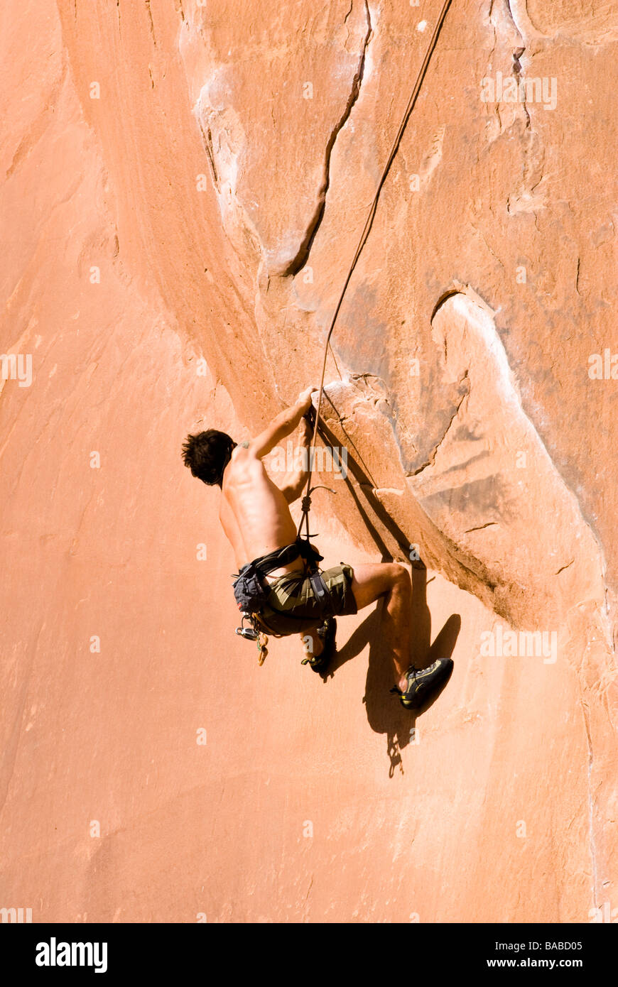 a rock climber ascending a sandstone wall near Moab Utah USA Stock ...
