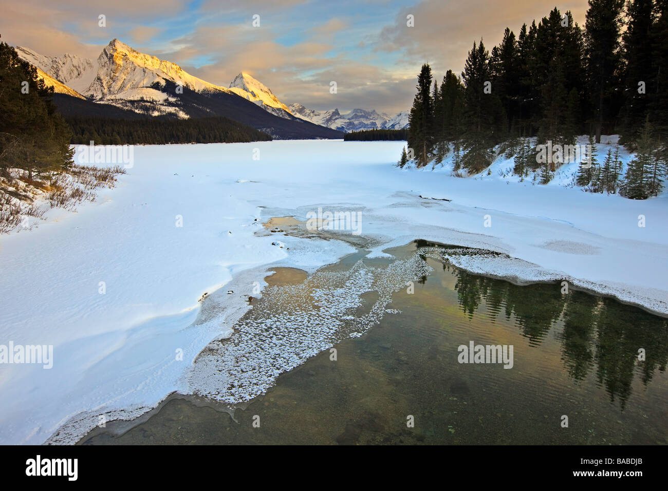 Partially frozen river with a view towards snow-capped mountains Stock ...