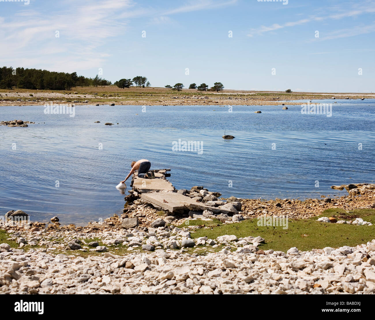 A woman on a jetty getting water Faro Gotland Sweden Stock Photo - Alamy