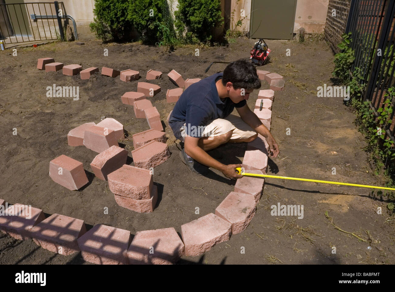 Hispanic Italian landscaping architect laying pavers for raised flower ...