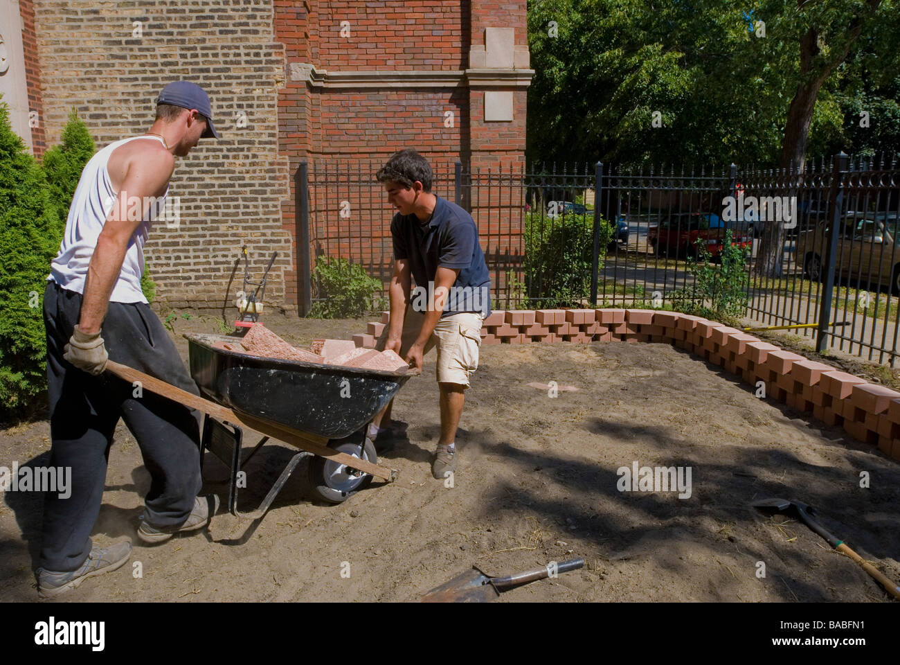 Hispanic Italian landscaping architect laying pavers for raised flower ...