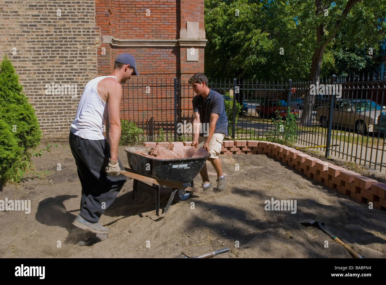 Hispanic Italian landscaping architect laying pavers for raised flower ...
