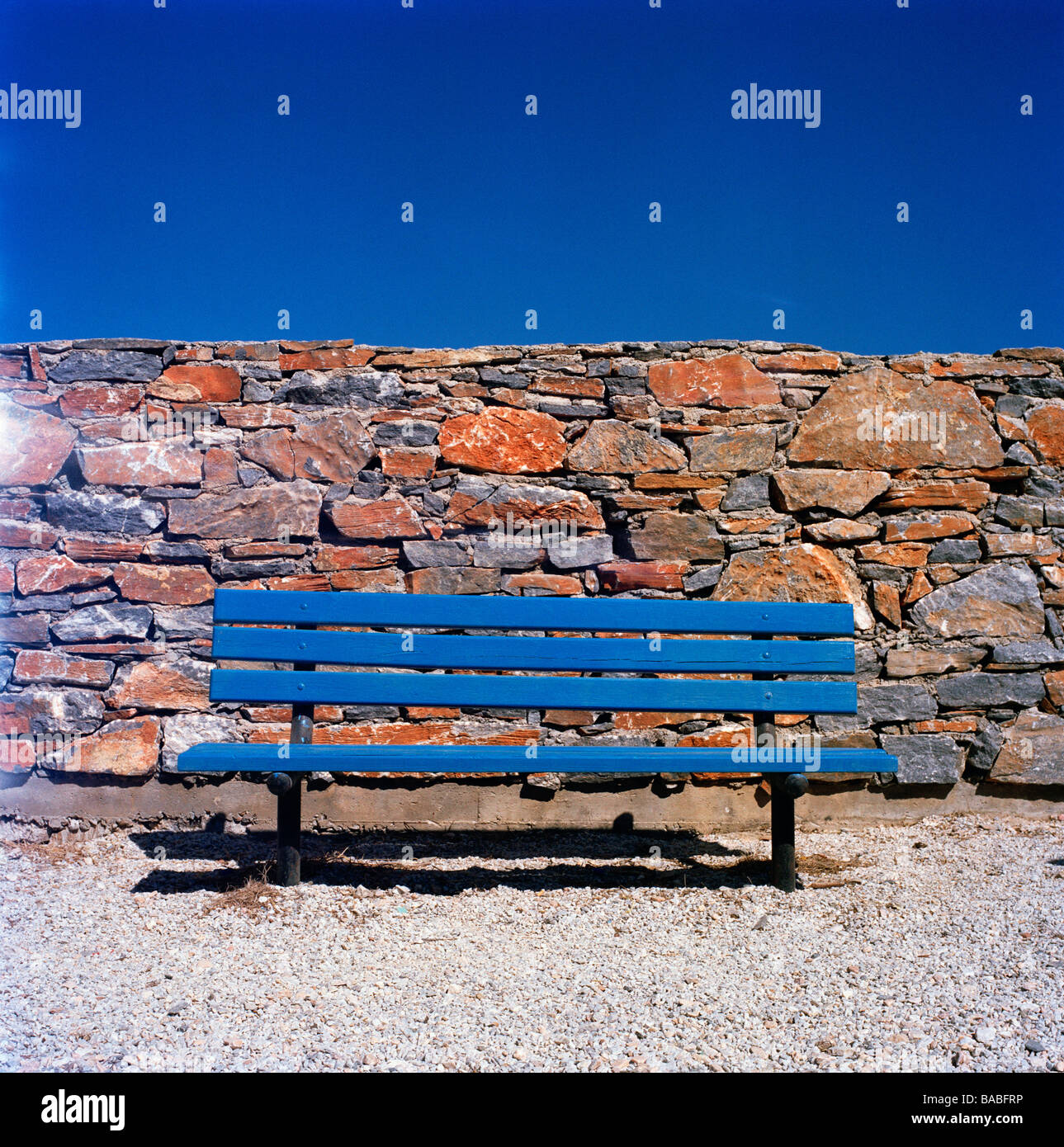 Blue settle by a stone wall Greece Stock Photo - Alamy