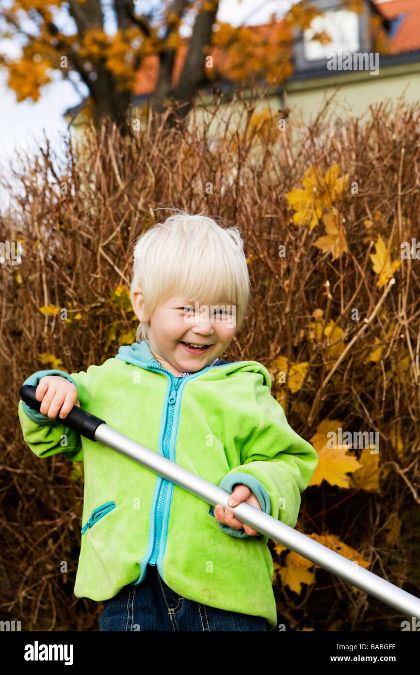 A little boy raking leaves in the garden Sweden Stock Photo - Alamy