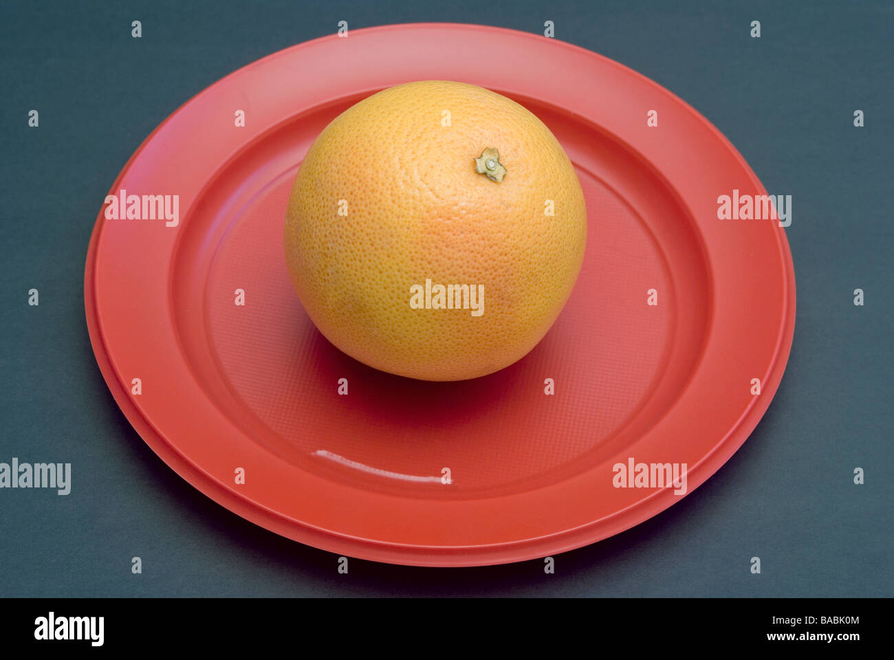 pink grapefruit on plastic plate Stock Photo - Alamy