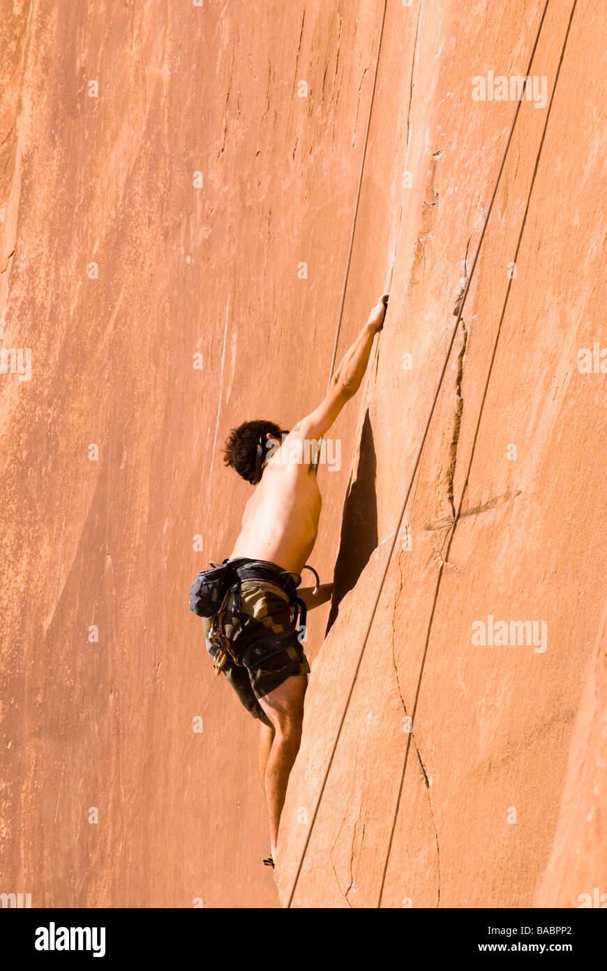 a rock climber ascending a sandstone wall near Moab Utah USA Stock ...