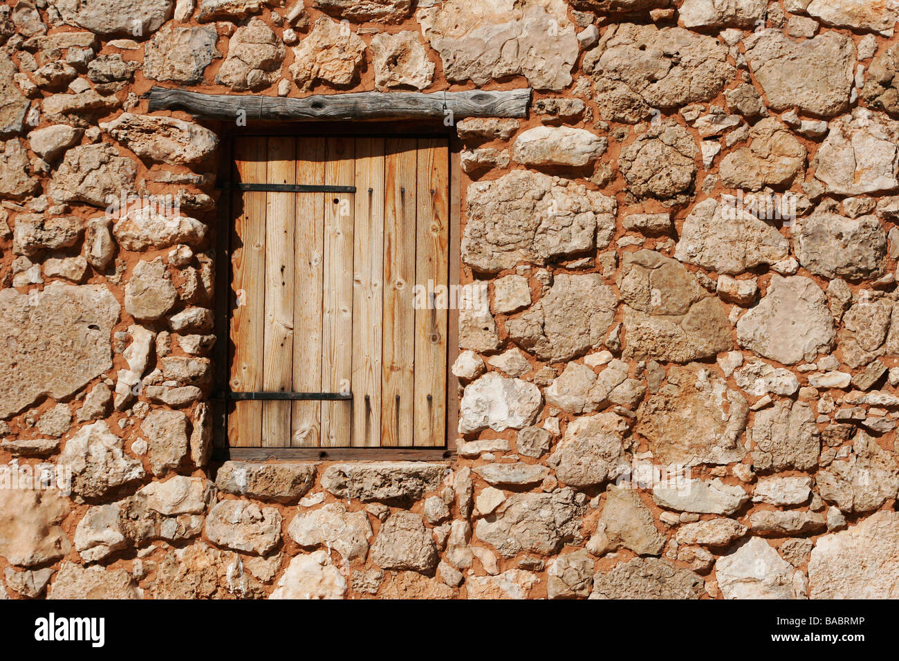 A wooden window sits in a stone wall in a hut built in South Africa's ...