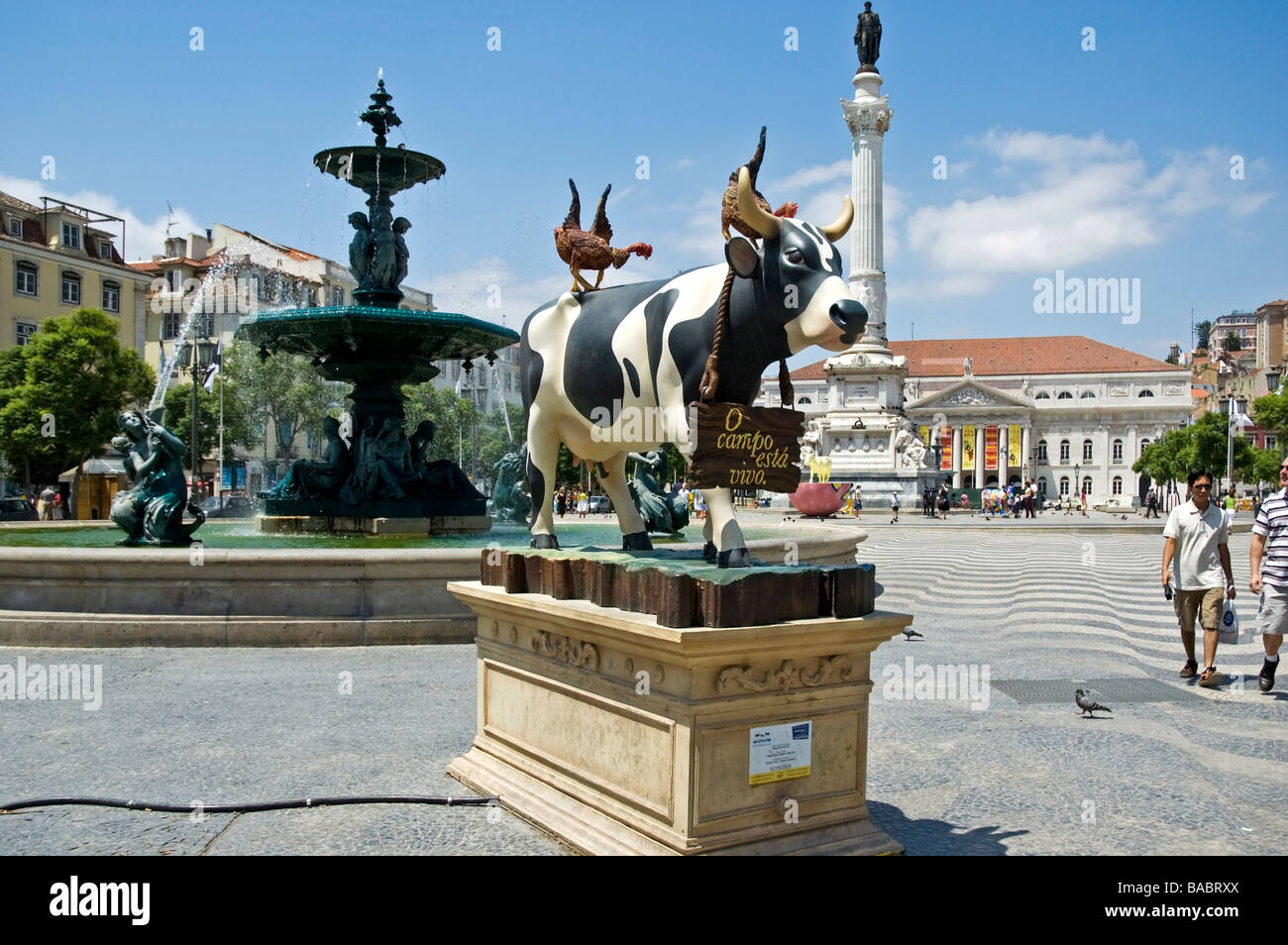 Chickens peck on the back of a full size black and white fibreglass cow ...