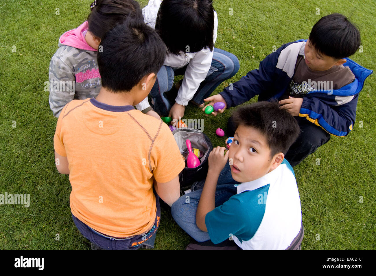 A small group of Asian children counting their eggs during an Easter ...