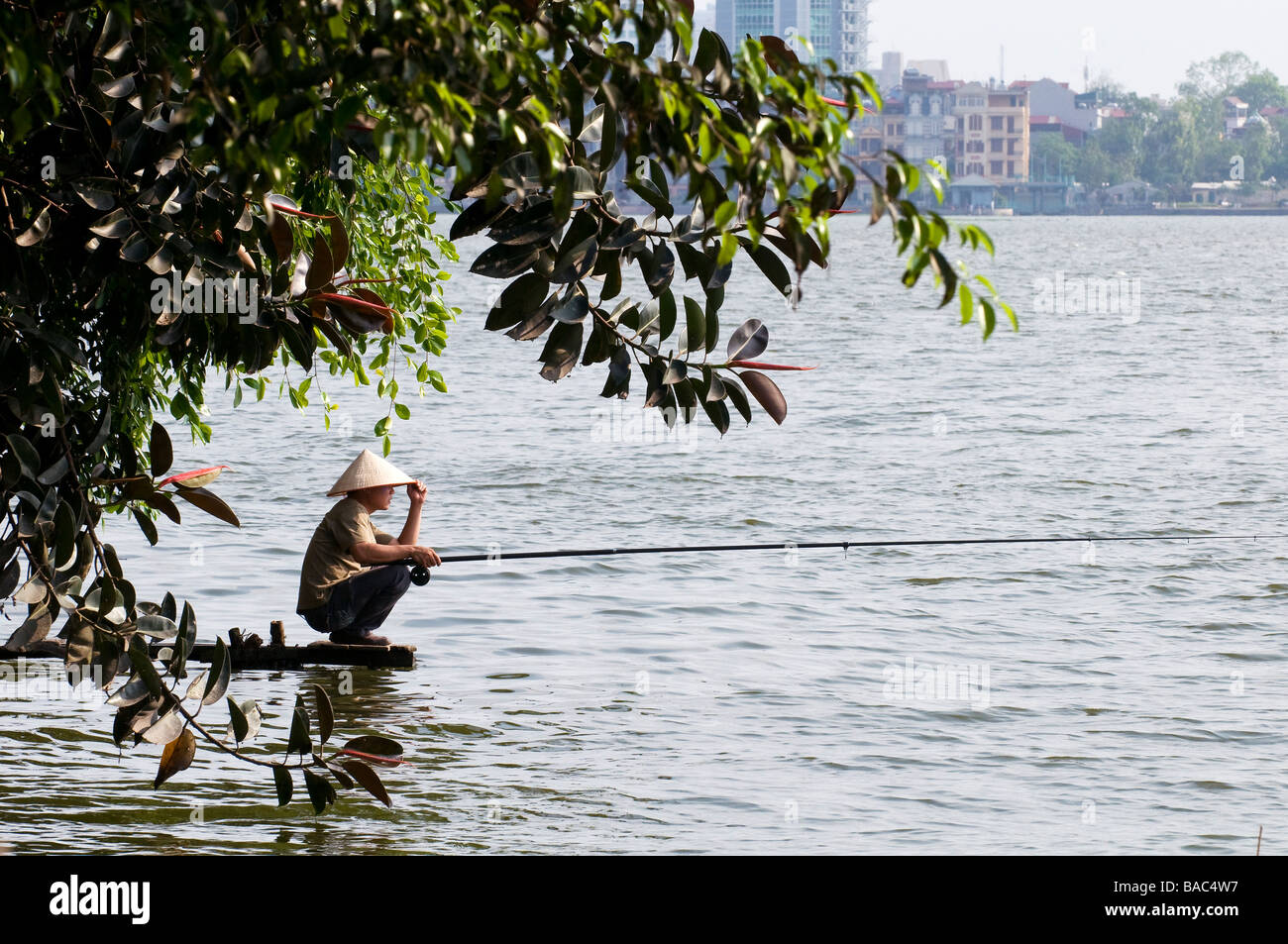 Vietnam, Hanoi, Ho Tay Lake in the west, a man fishing Stock Photo - Alamy