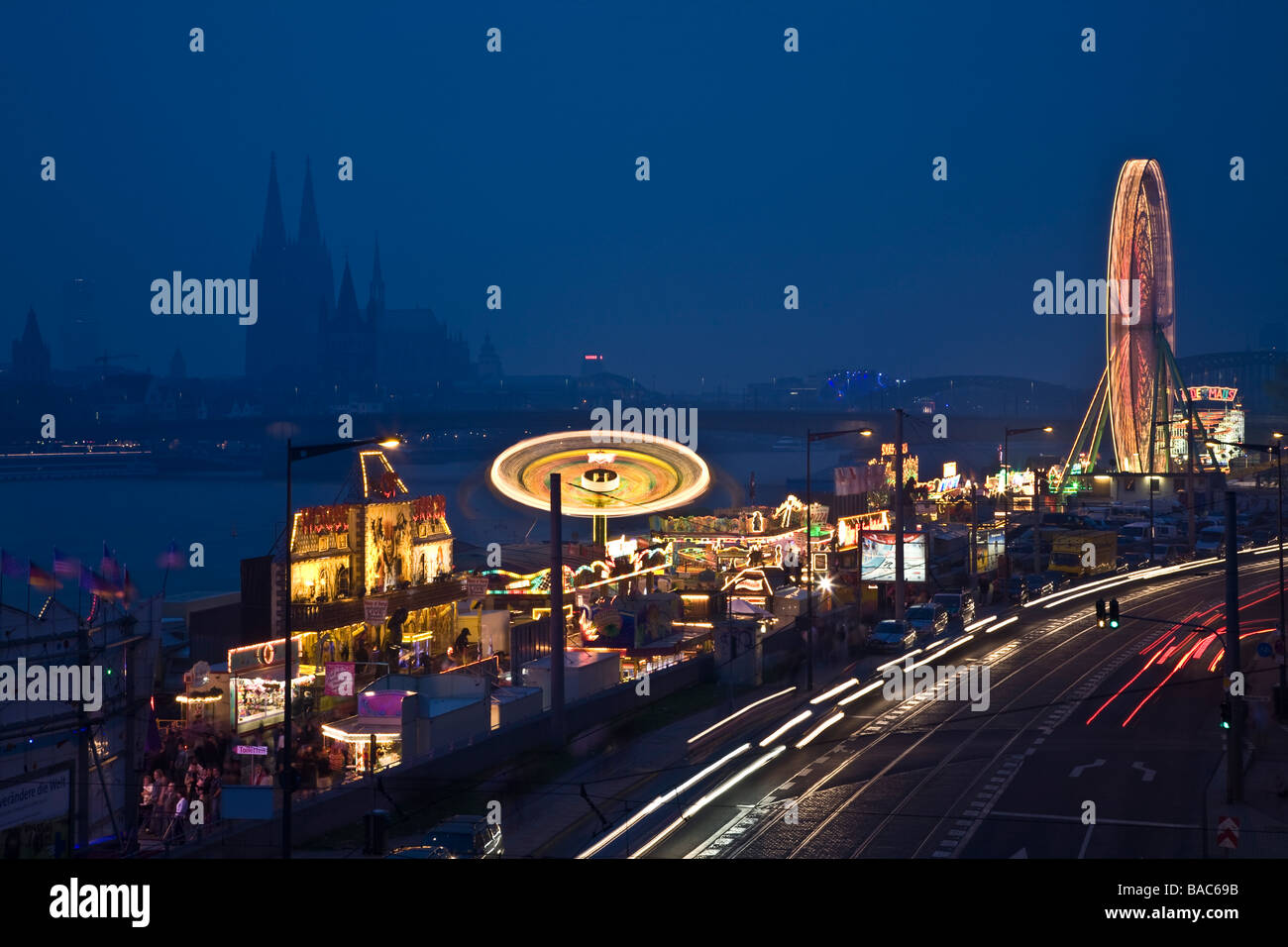 Fair at night beside the Rhine in Cologne with silhouette of Cologne ...
