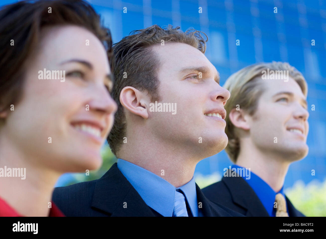 Business team looks ahead as they stand together and smile Stock Photo ...