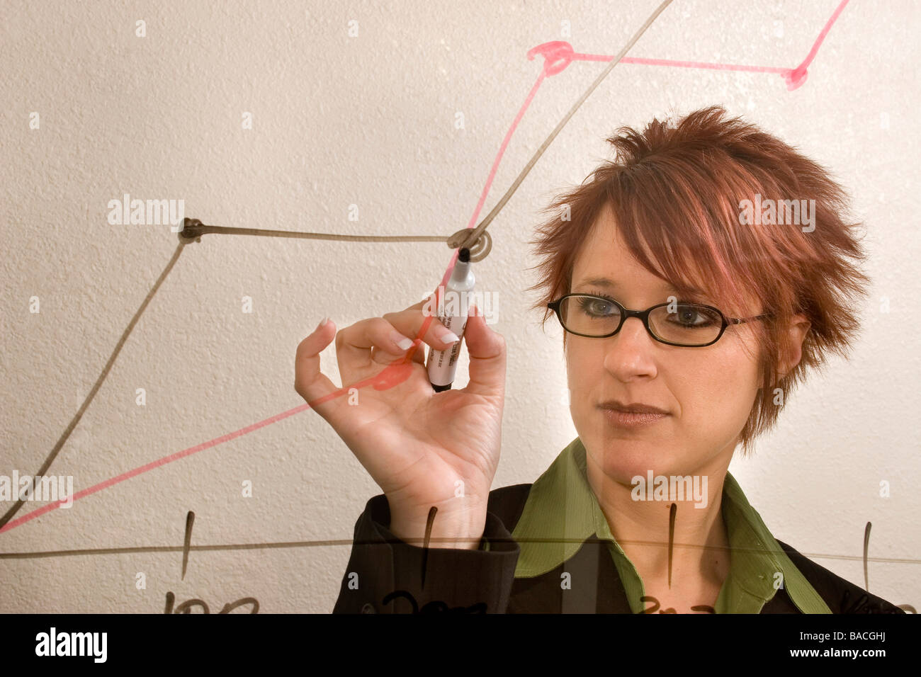 Businesswoman drawing a line graph on a transparent sheet Stock Photo ...