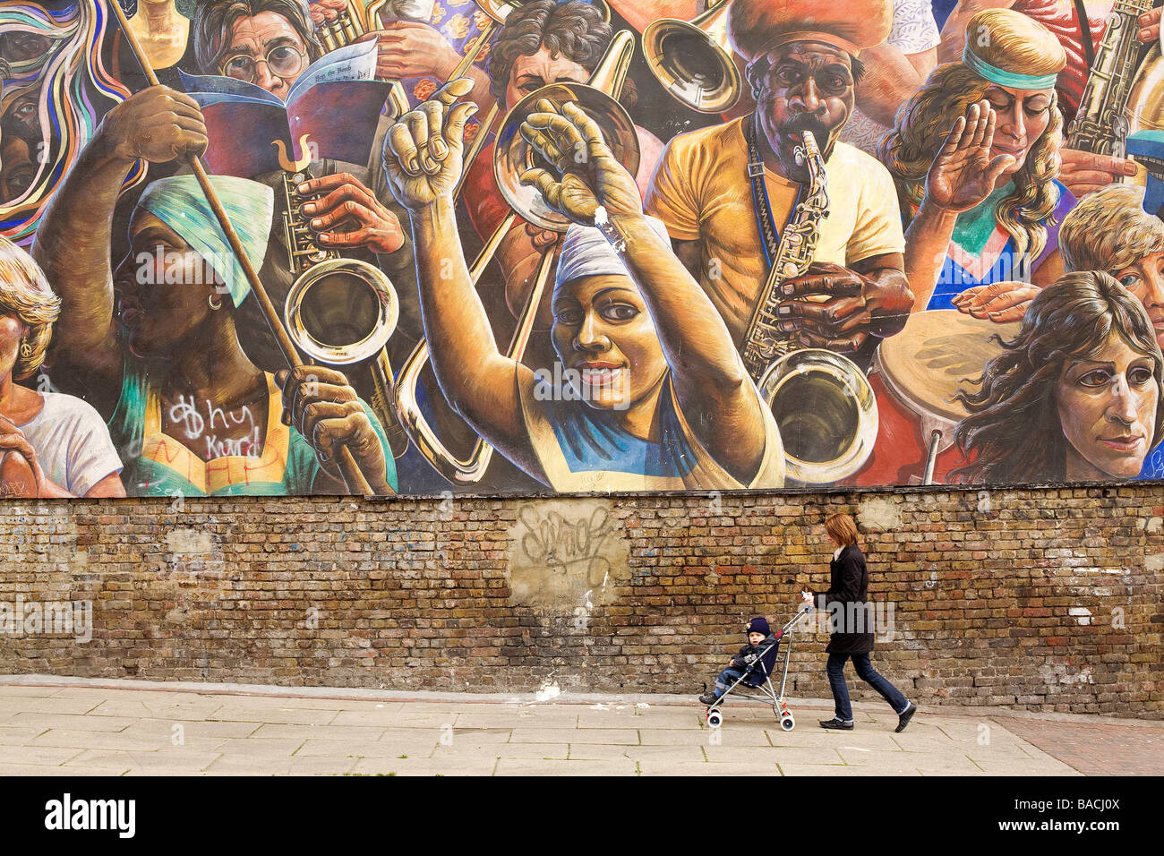 United Kingdom, London, Hackney, Dalston Lane, young mother passing in ...