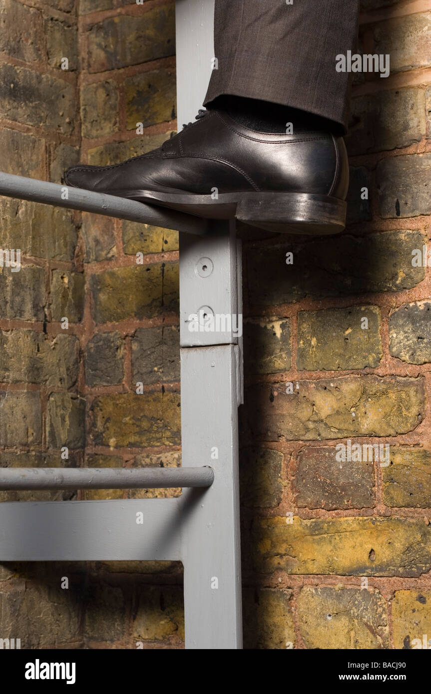 Low section view of a man climbing up a ladder Stock Photo - Alamy