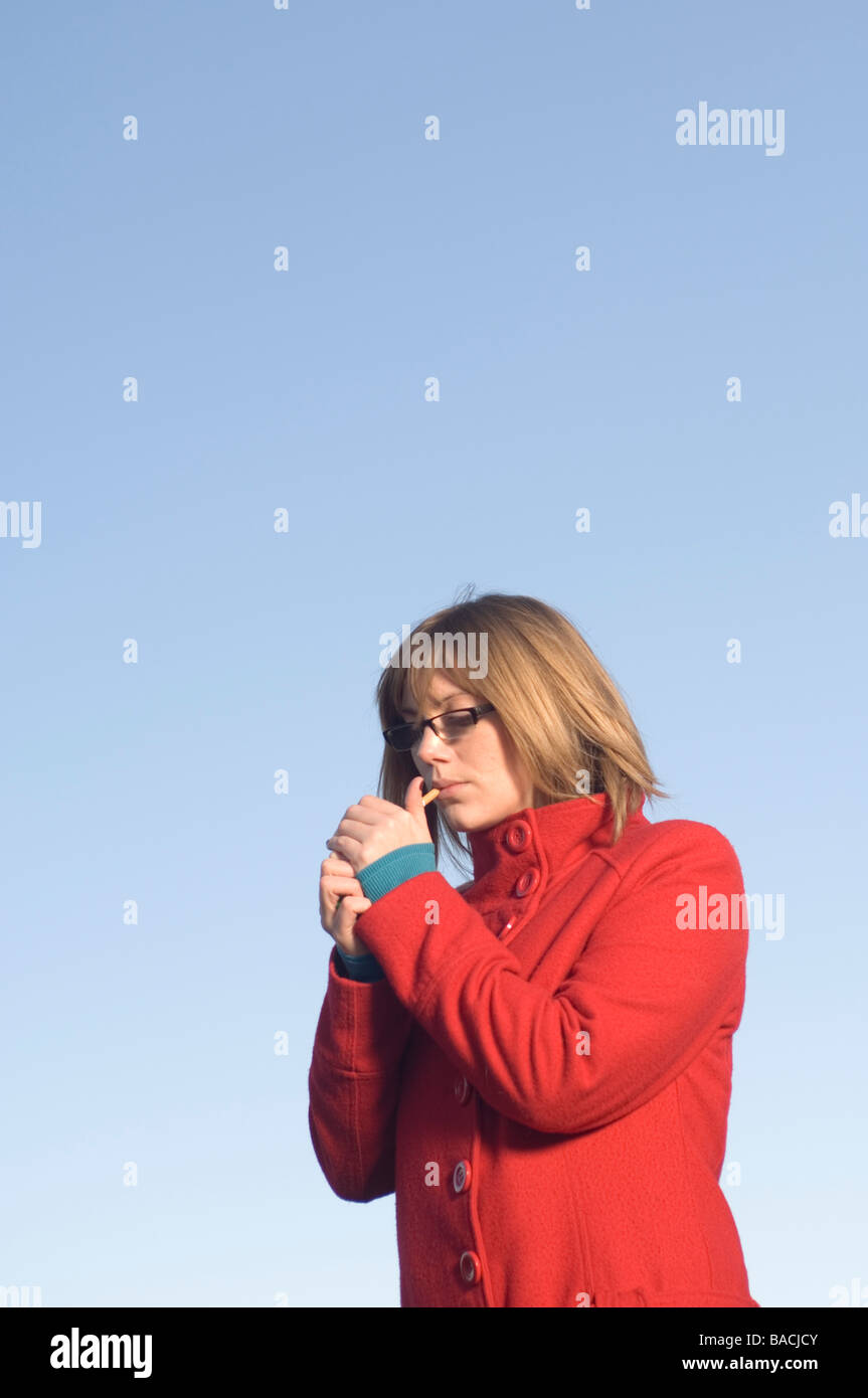 Mid adult woman smoking a cigarette Stock Photo - Alamy