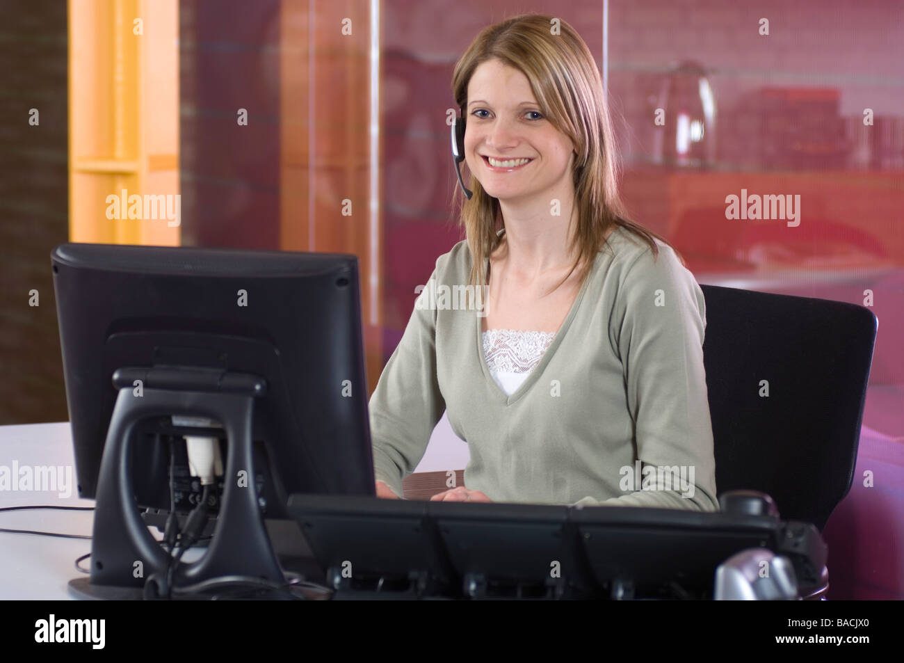 Female customer service representative sitting in front of a computer ...