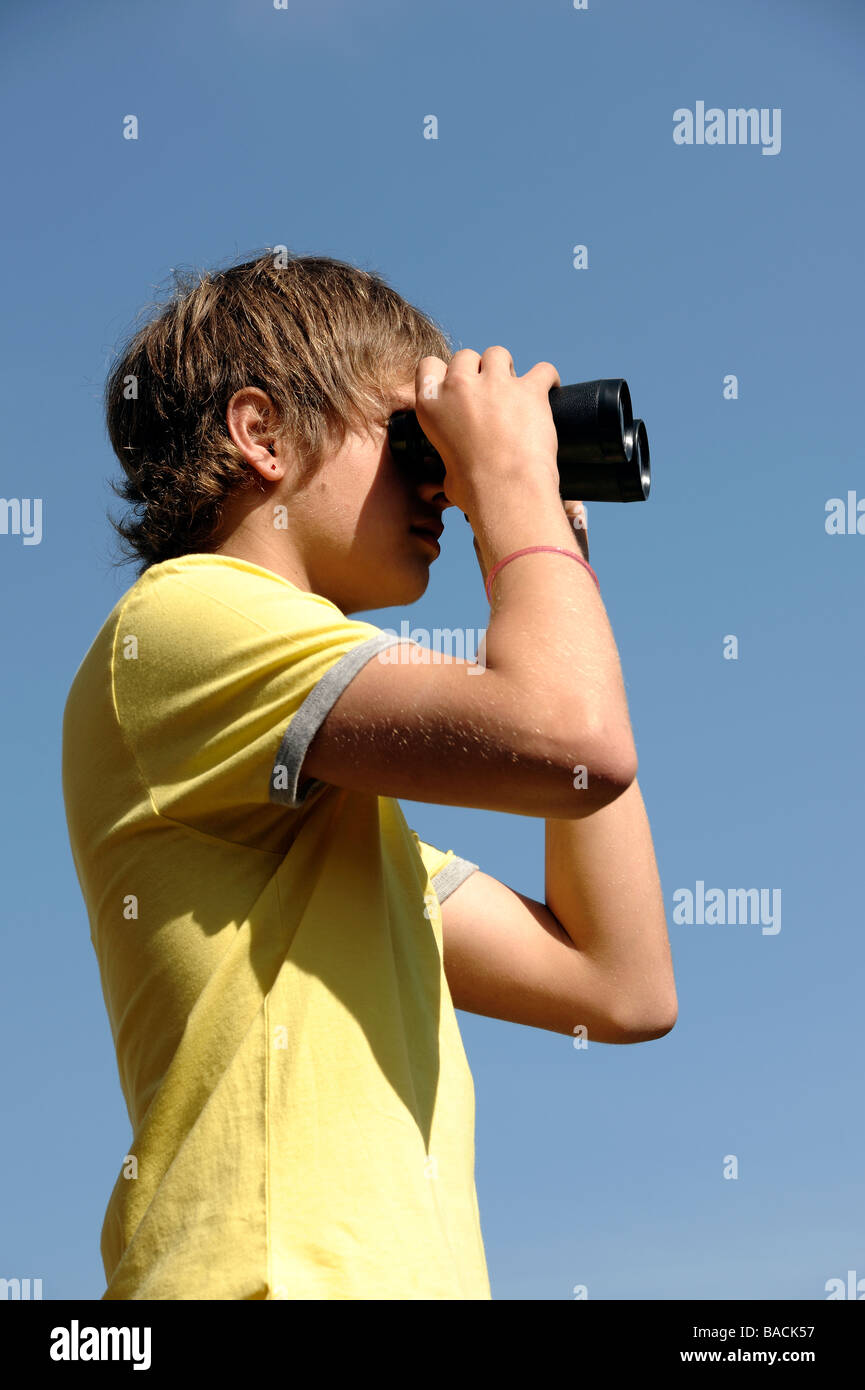 Boy looking through binoculars Stock Photo - Alamy