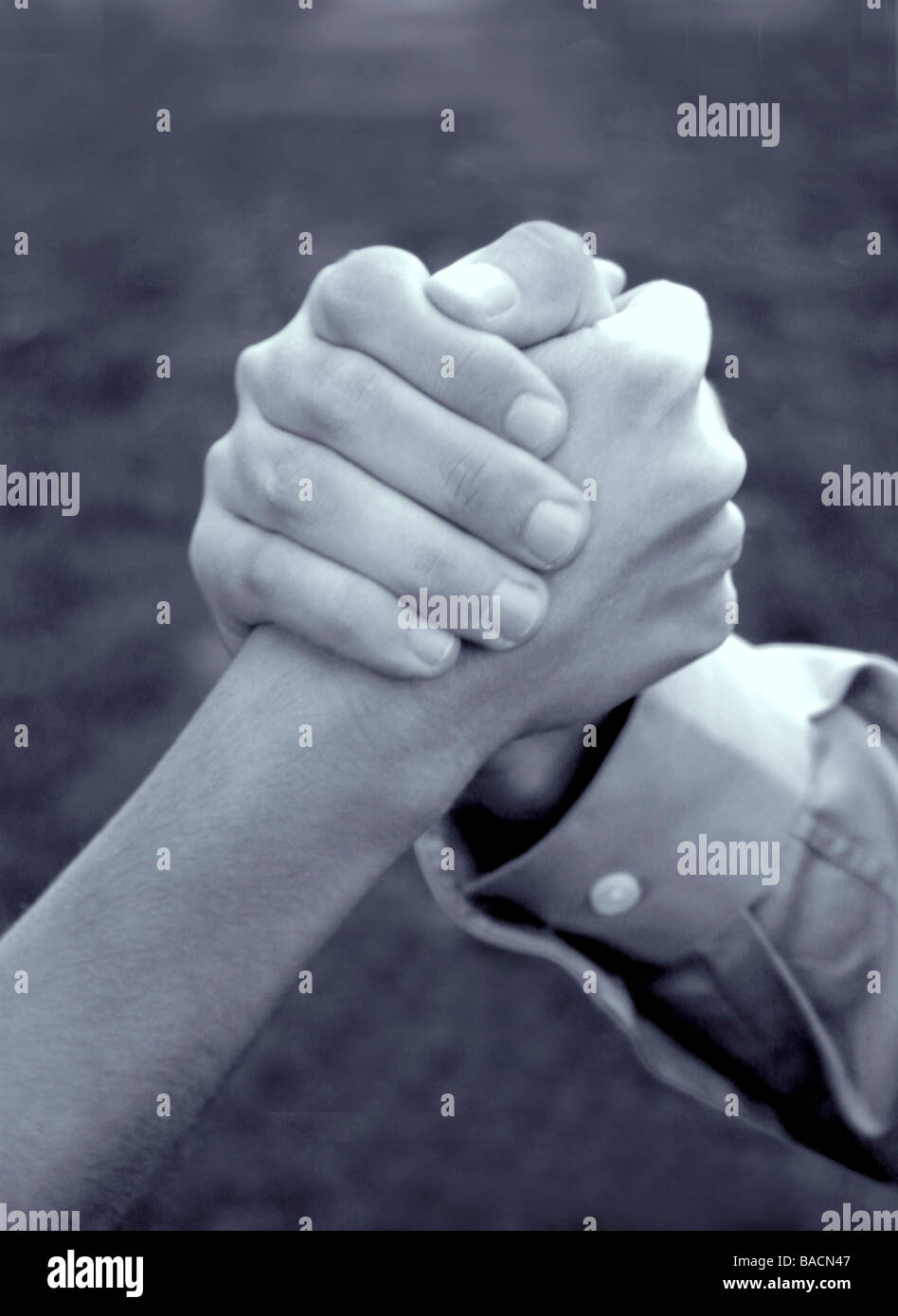 Hand of woman and hand of man is clasped together in symbolic strength ...