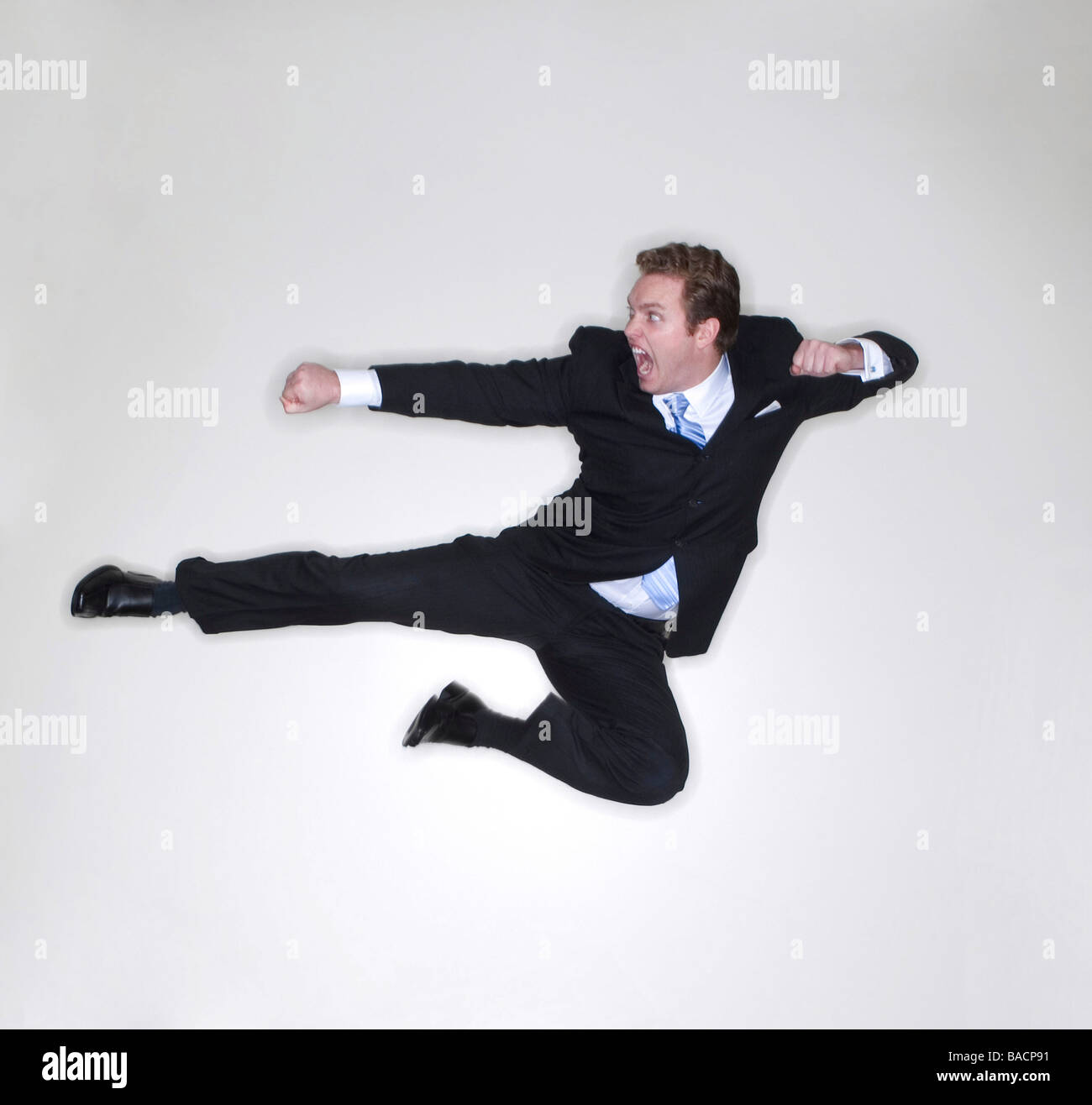 Businessman gives a karate kick in the air inside the office Stock ...