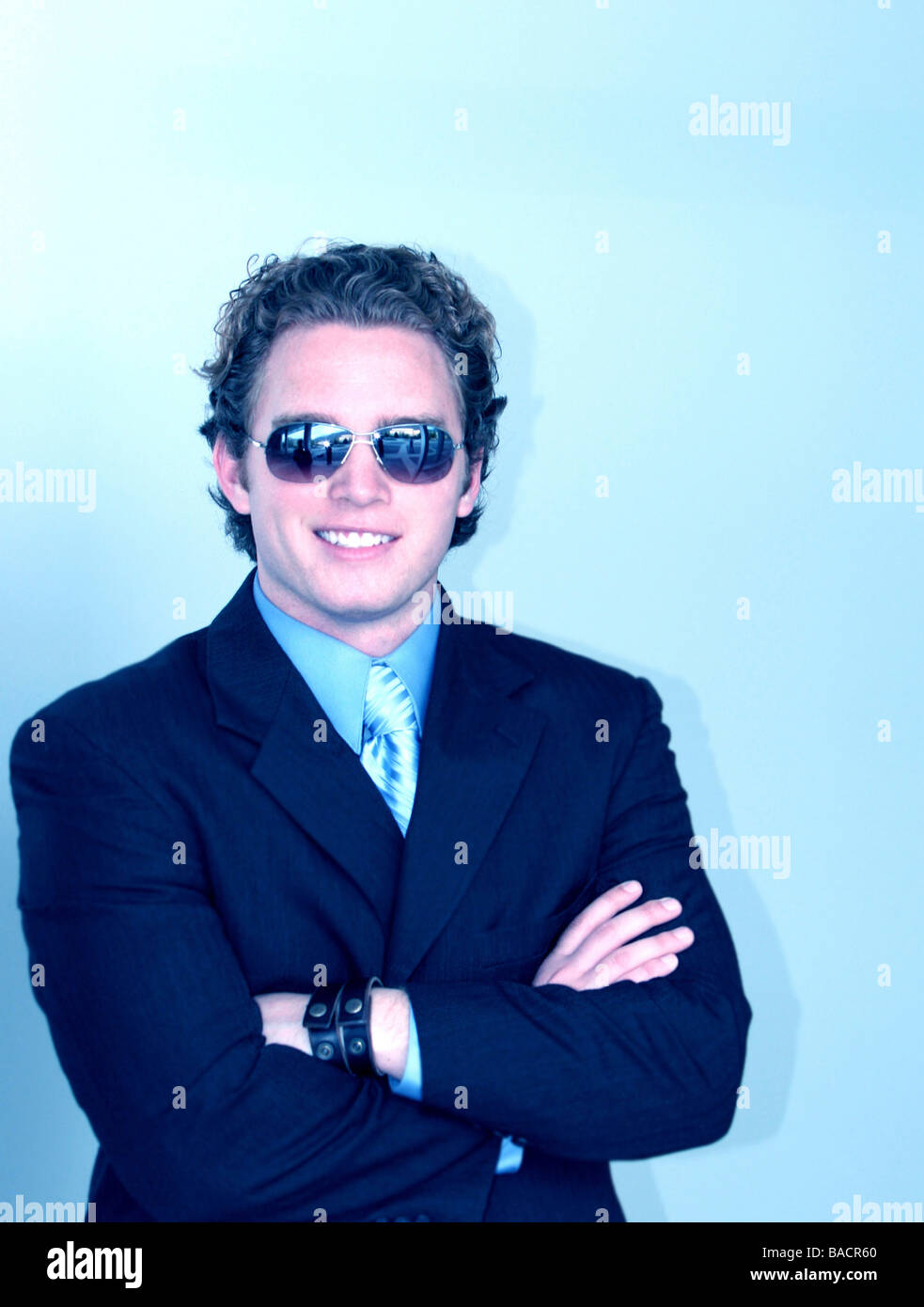 Young, business leader with sunglasses and dark blue suit is smiling ...