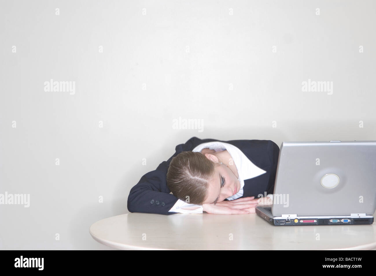 Businesswoman taking a nap next to her laptop while working Stock Photo ...