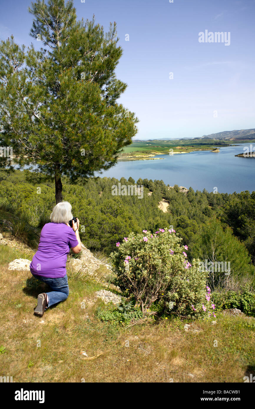 Female woman tourist kneels down to photograph the Embalse del ...