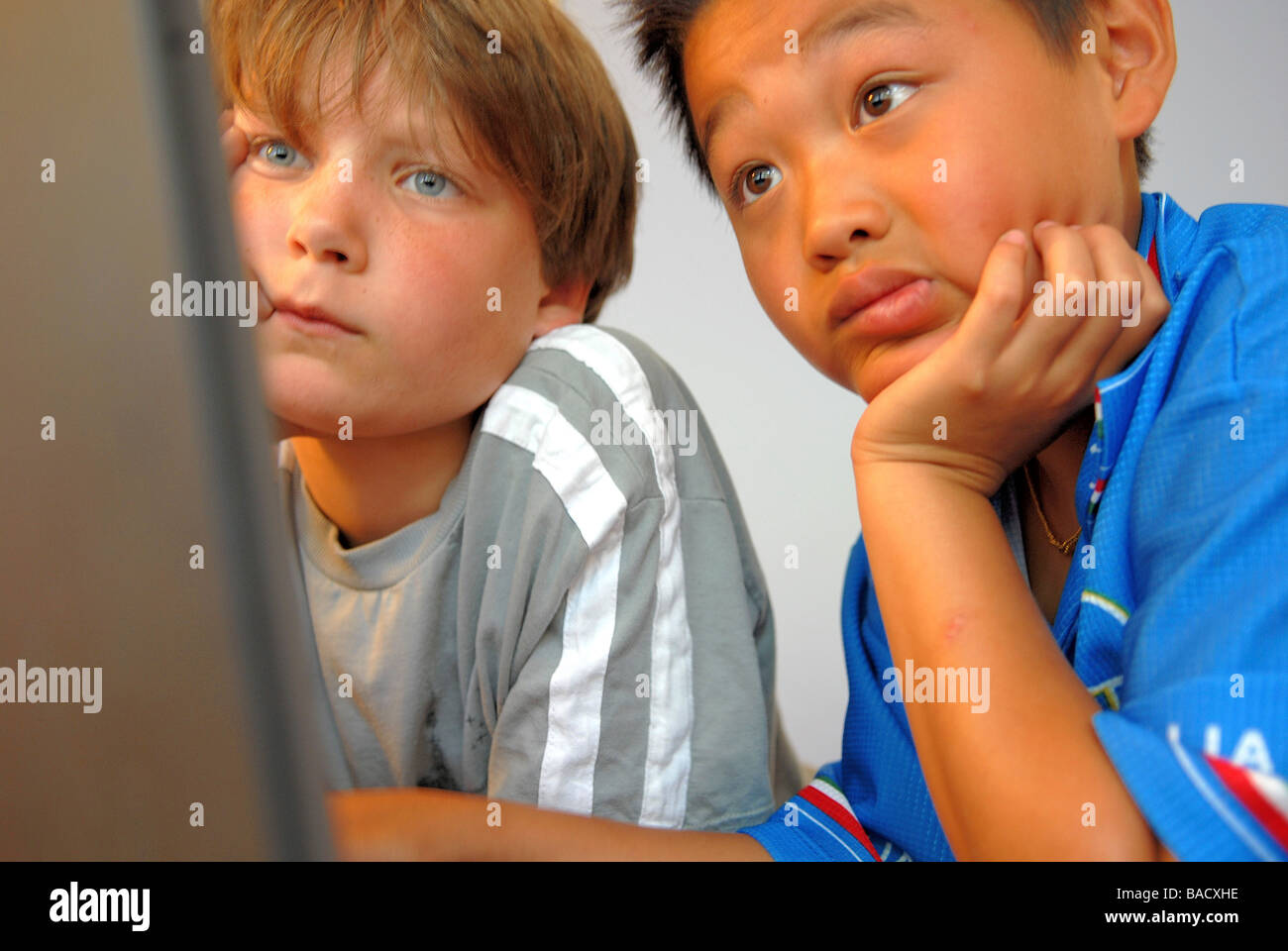 Two boys looking at a computer Stock Photo - Alamy