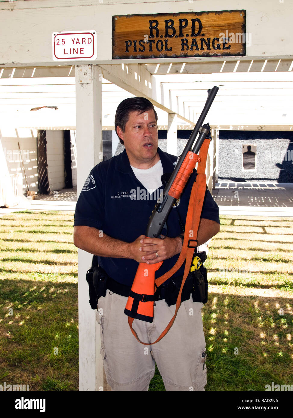 Range officer holds non lethal 12 gauge shotgun while demonstrating to ...